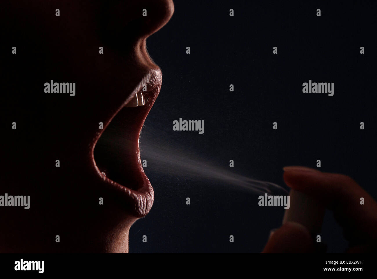 open mouth of a woman who is applying mouth spray Stock Photo - Alamy