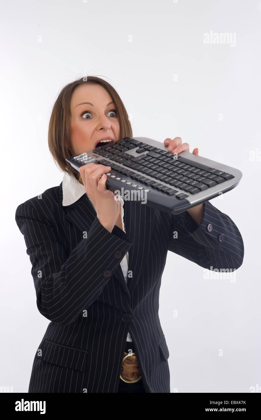 business woman bites into keyboard Stock Photo - Alamy
