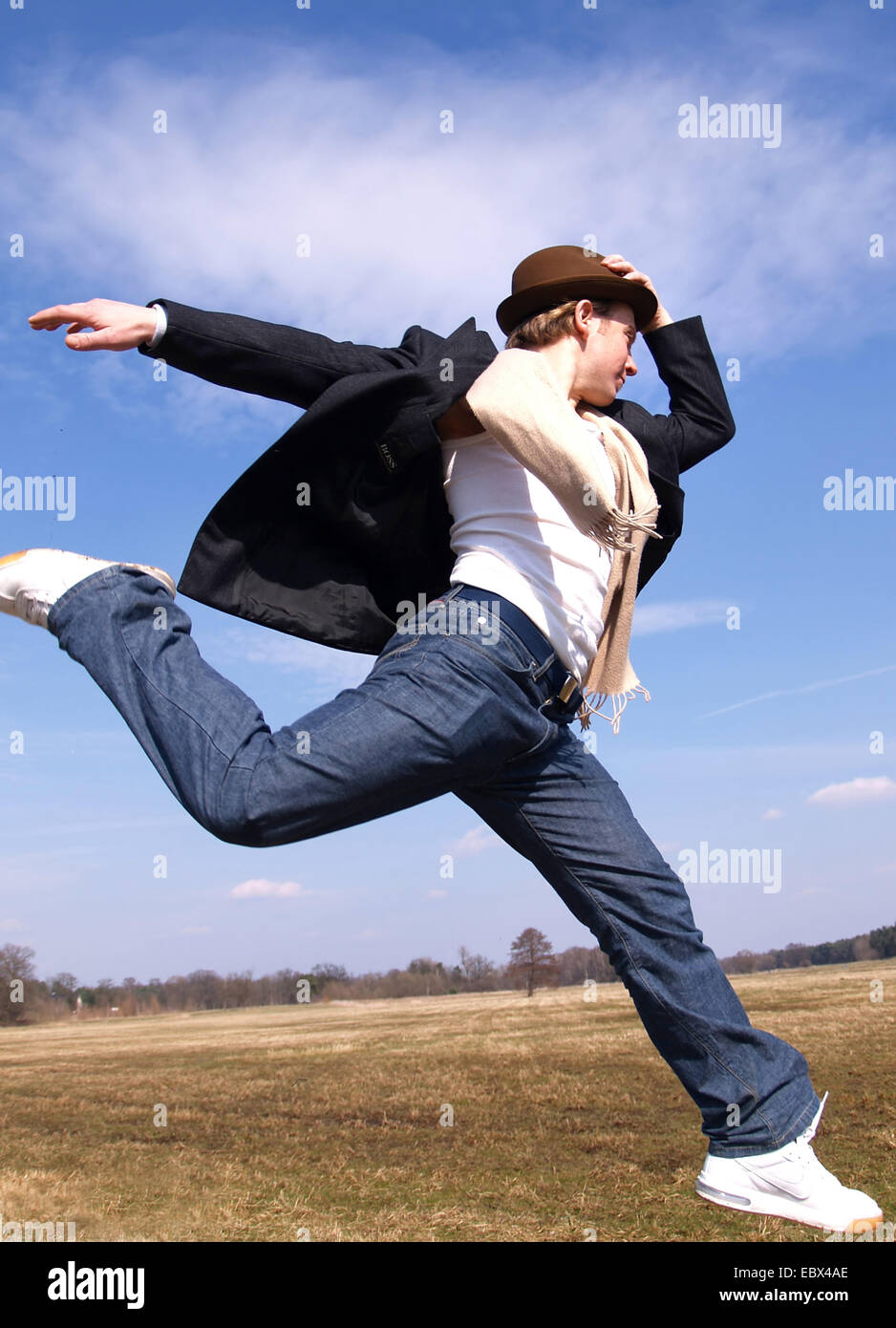 young man jumping through a meadow Stock Photo - Alamy