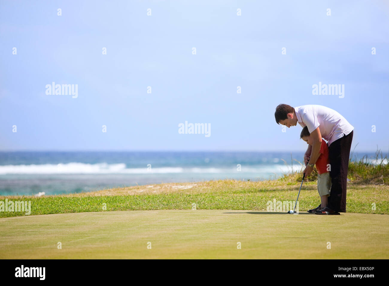 Father teaching his sun to play golf on a golf course Stock Photo - Alamy