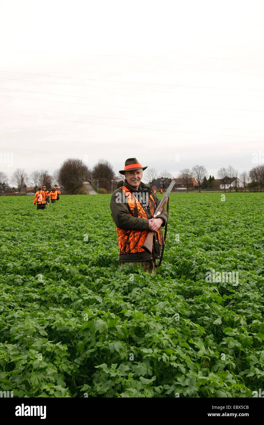 battue at the edge of a housing area, shooters scouring a field of ...