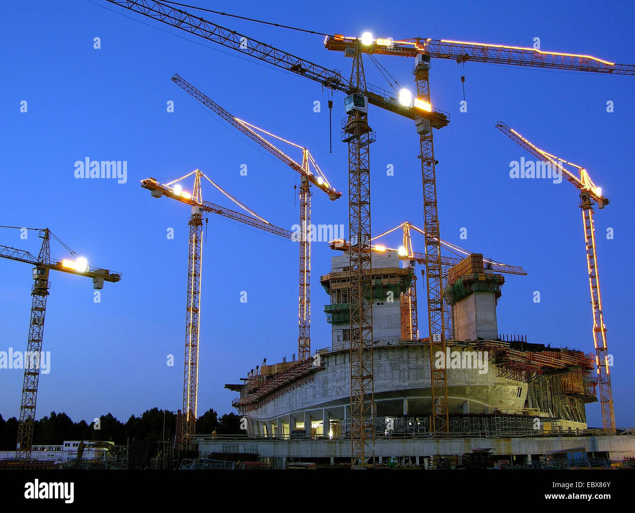 illuminated building cranes at a construction side in twilight Stock ...