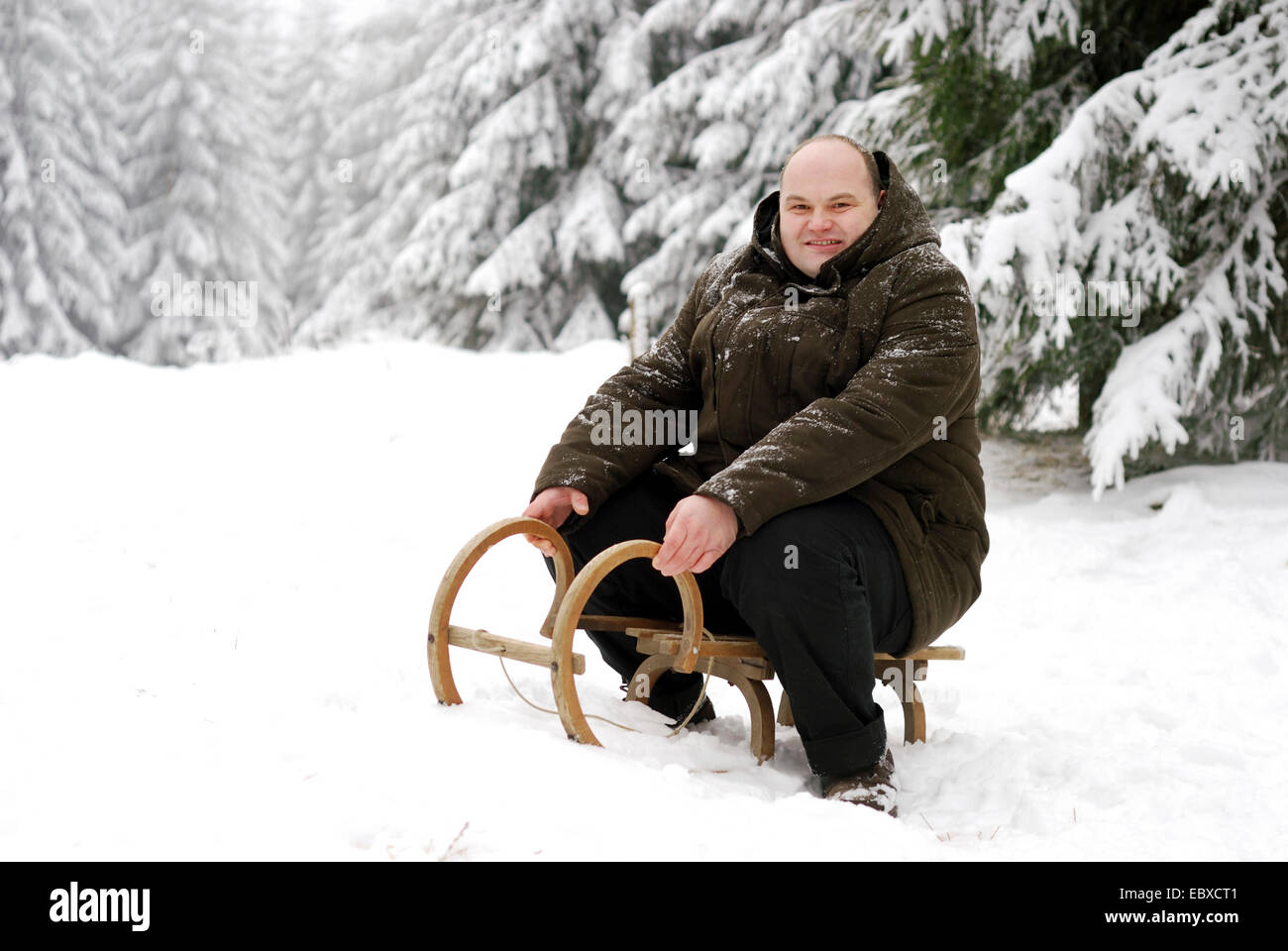 man sitting on sledge in snow Stock Photo - Alamy