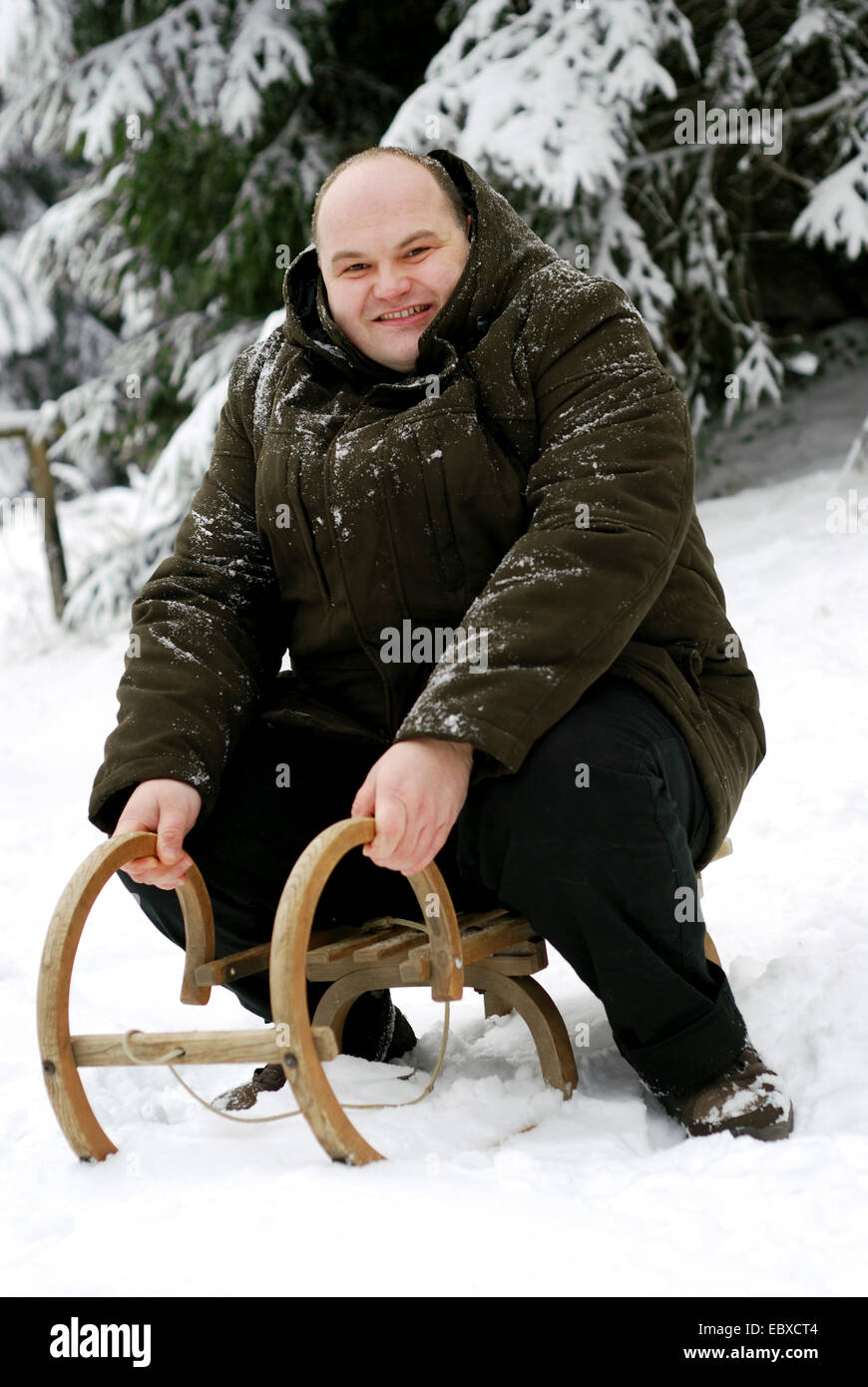 man sitting on sledge in snow Stock Photo - Alamy