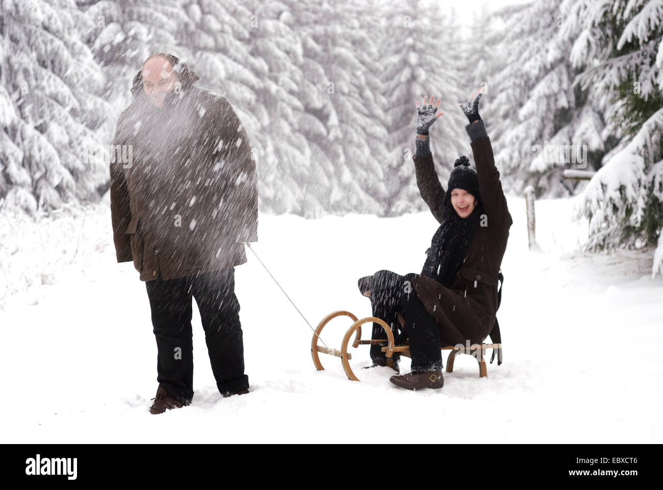 woman and man making winter holidays, woman sitting on sledge Stock ...