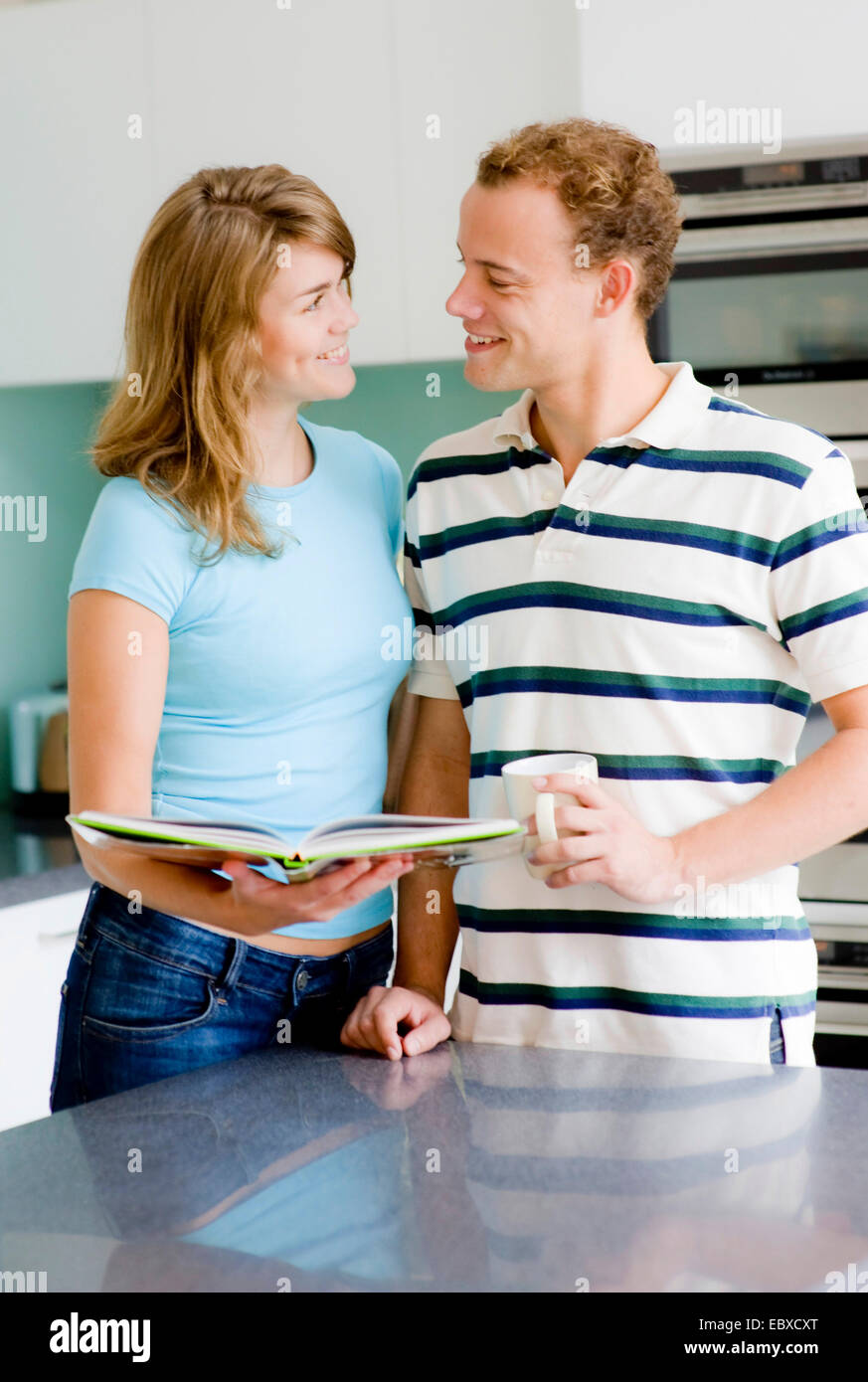young couple reading a cookbook in the kitchen Stock Photo - Alamy