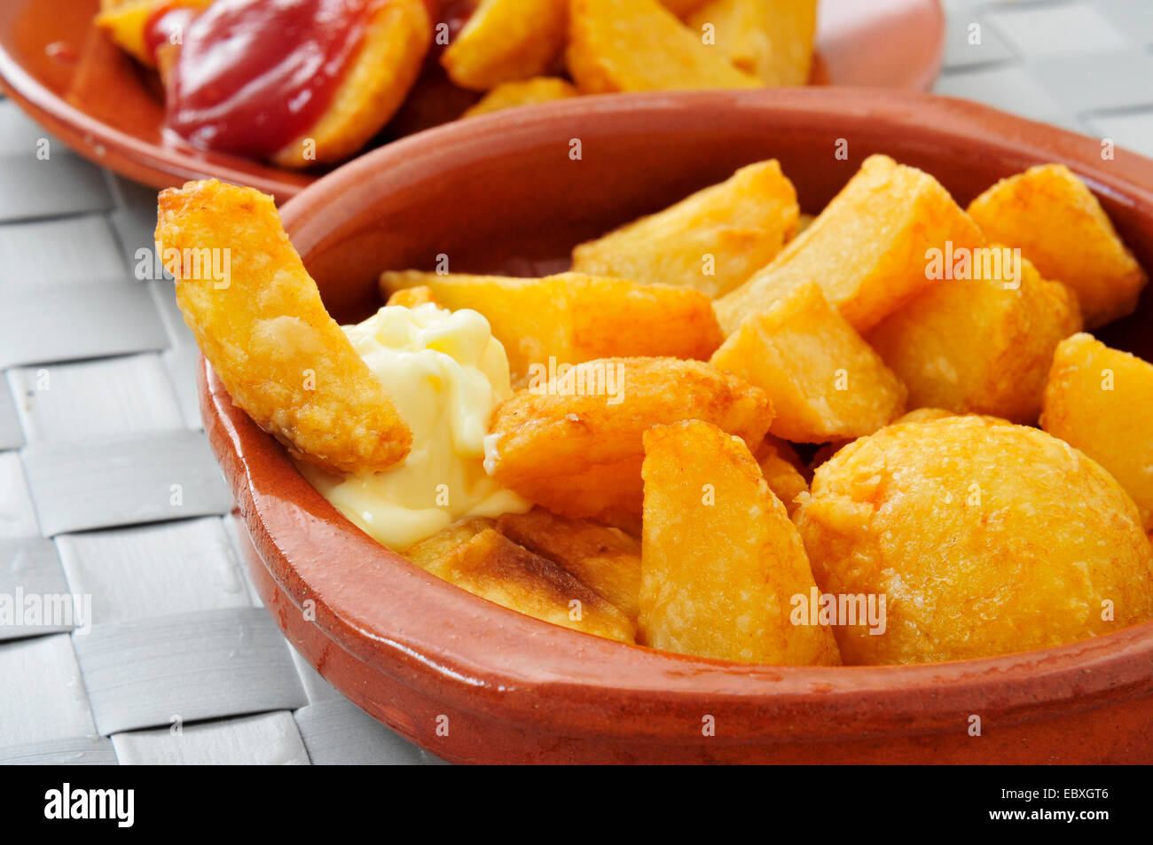 closeup of a plate with typical spanish patatas bravas, fried potatoes ...