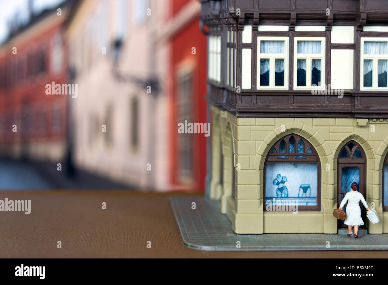 Close up of a model railway building, against a photograph of a street ...