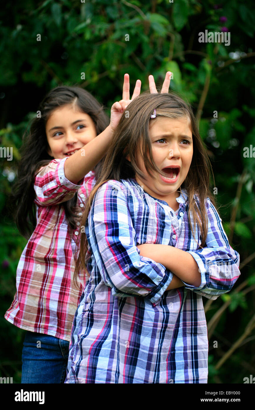 beautiful dark-haired girl kidding her sister Stock Photo - Alamy