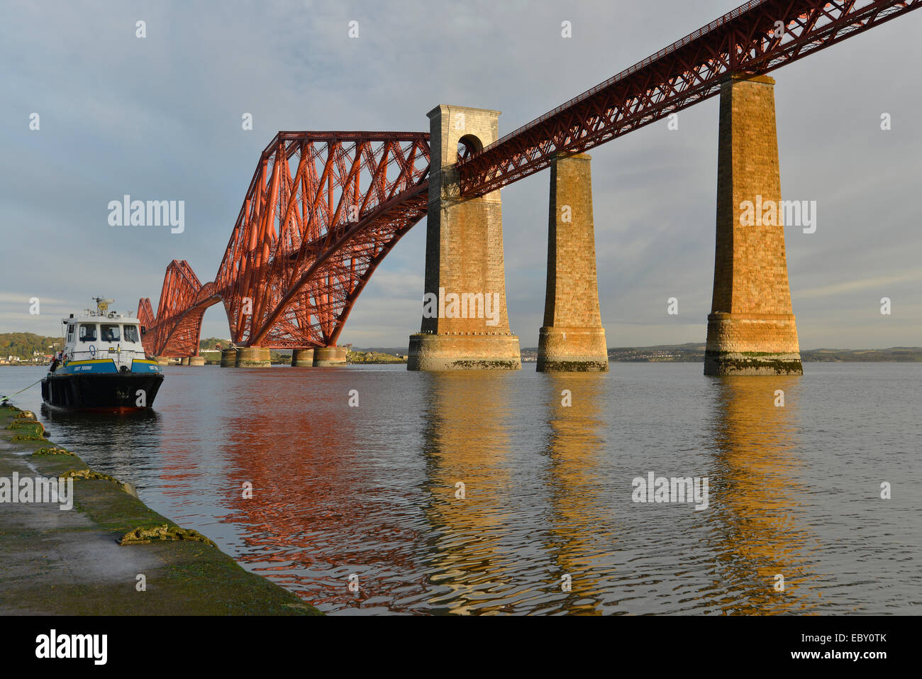 Boat jetty next to Forth Bridge railway bridge across Firth of Forth ...