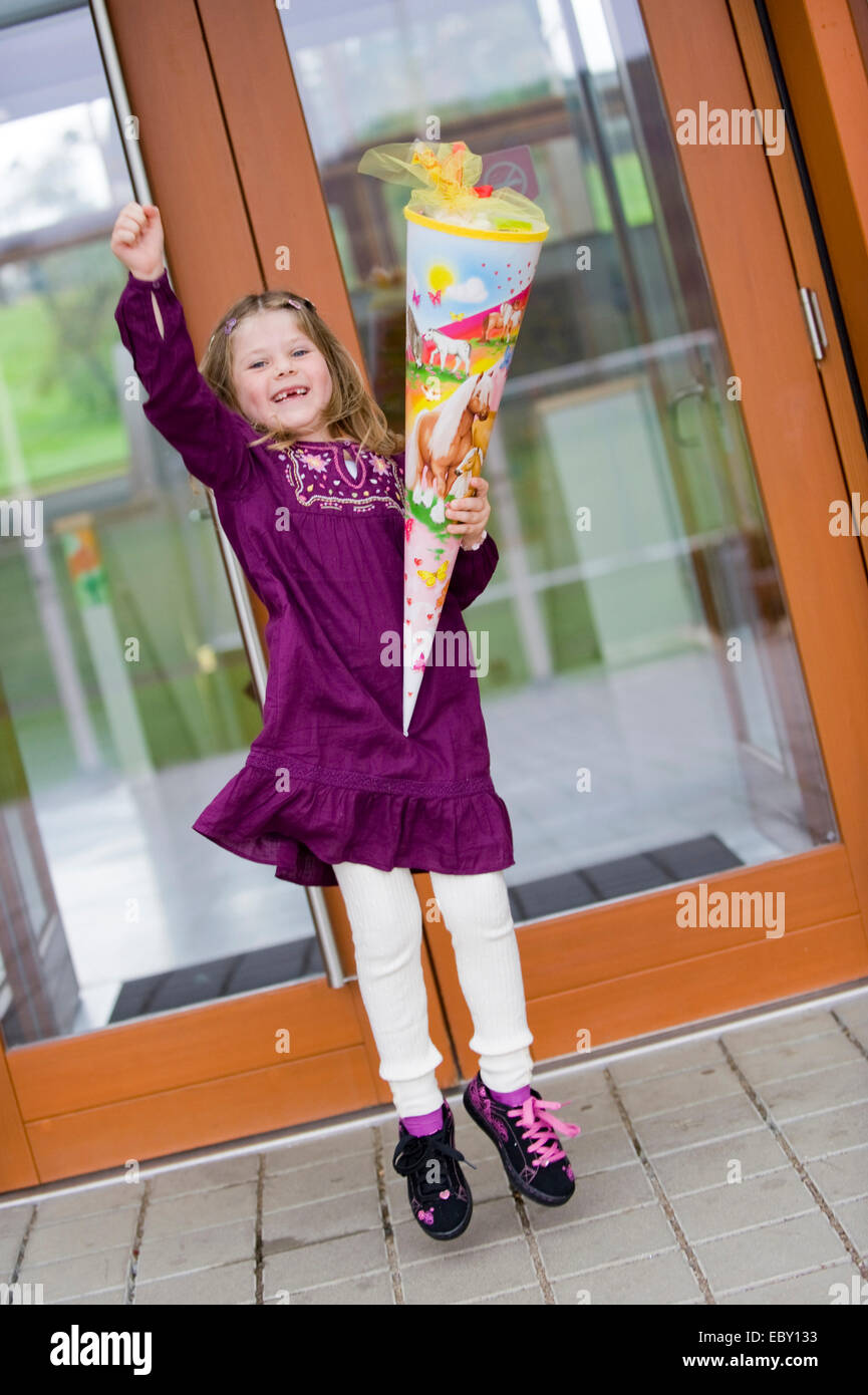 child starting school with school cone in front of the school cheering ...