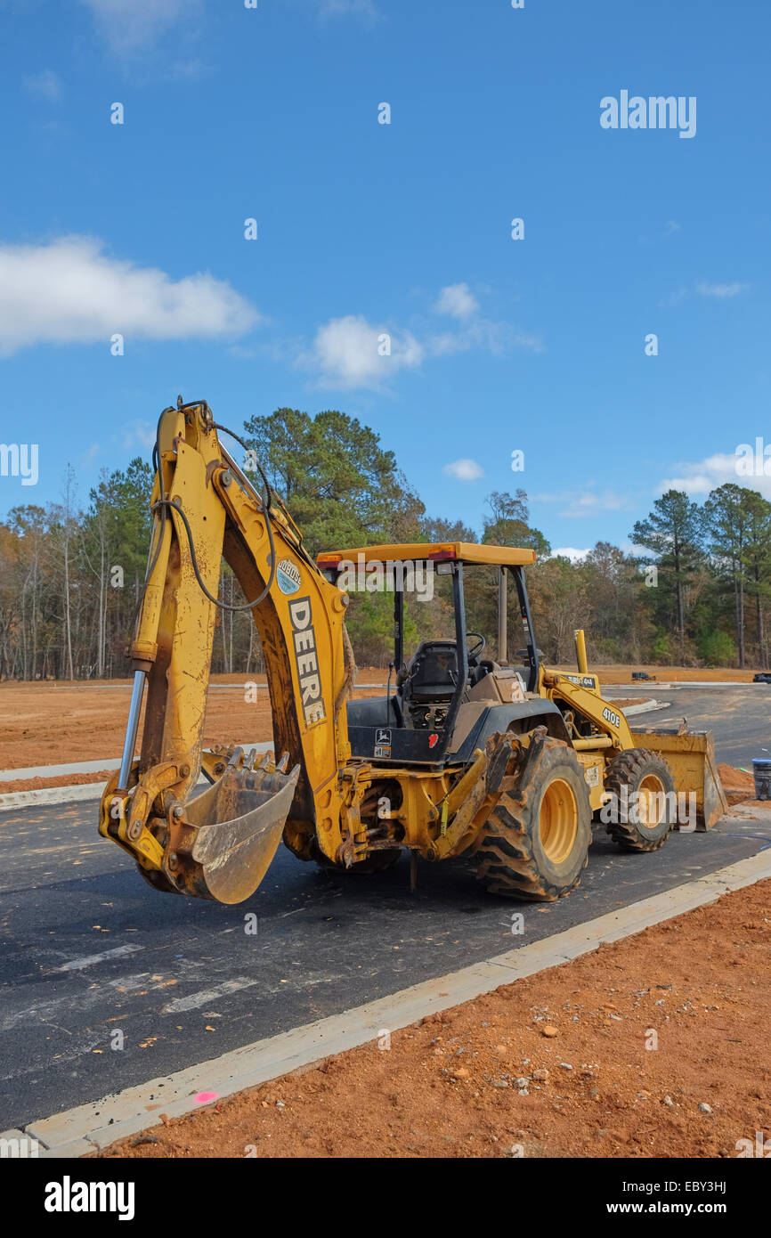 A Deere backhoe and front loader parked on a new road in a subdivision ...
