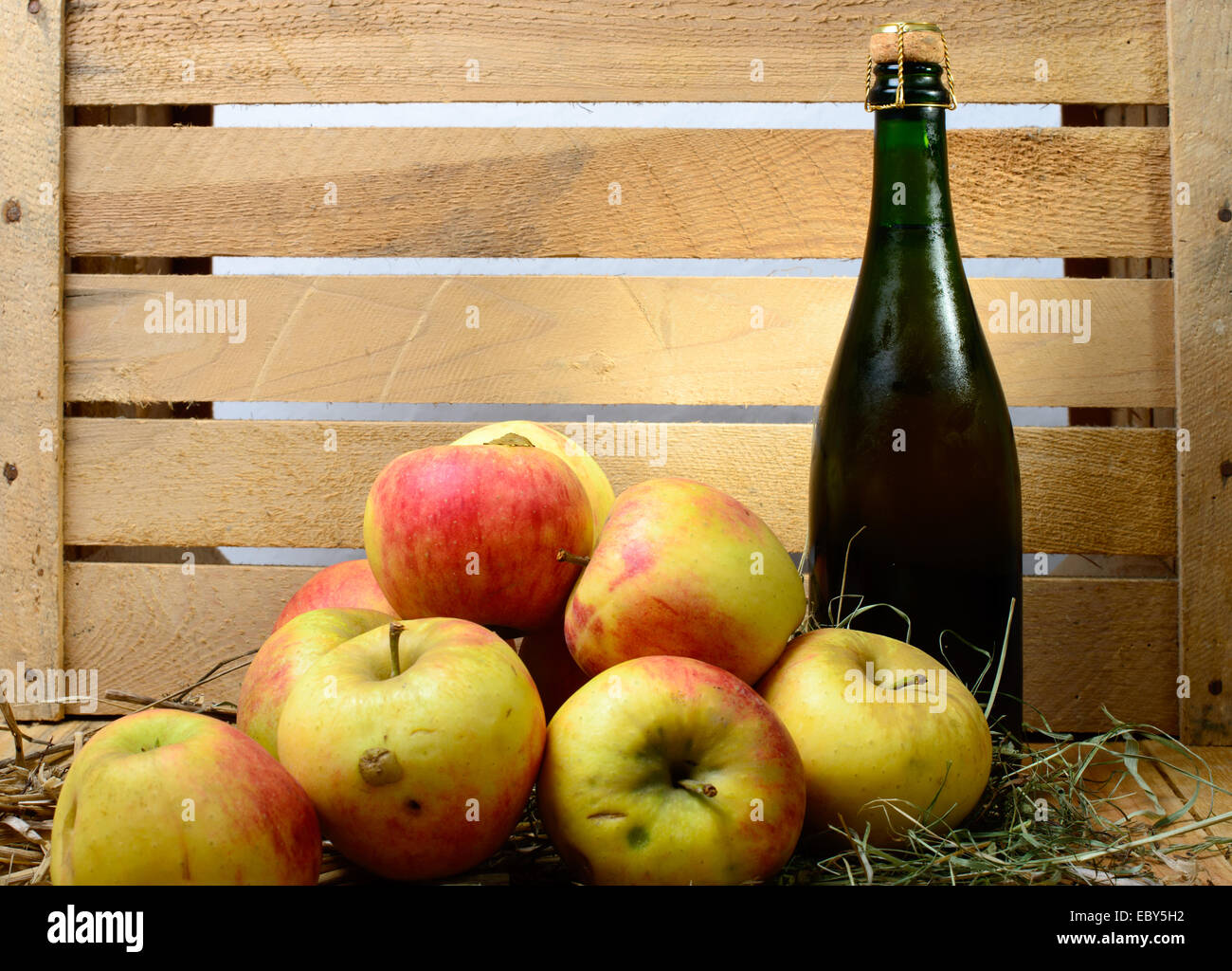 bottle of cider with some apples and straw Stock Photo - Alamy