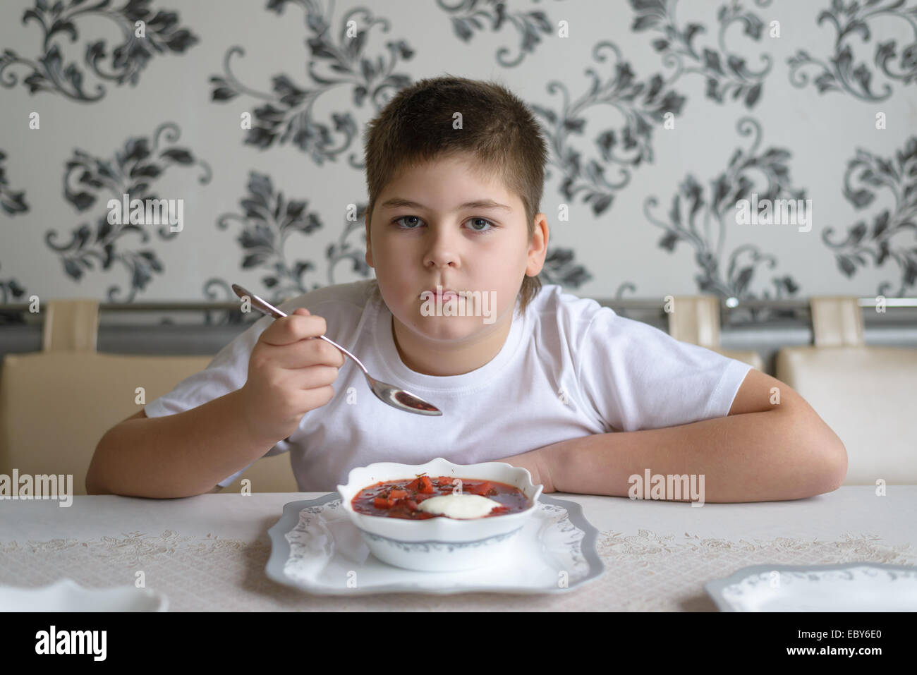 Boy teenager eating soup at kitchen table Stock Photo - Alamy