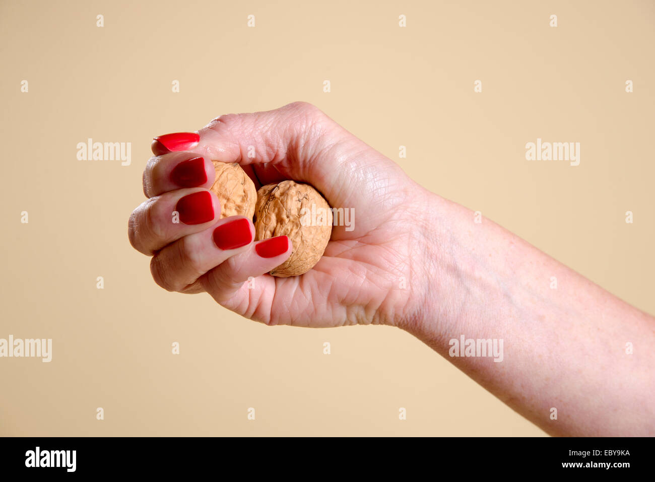 Walnuts in a woman's hand being crushed Stock Photo - Alamy