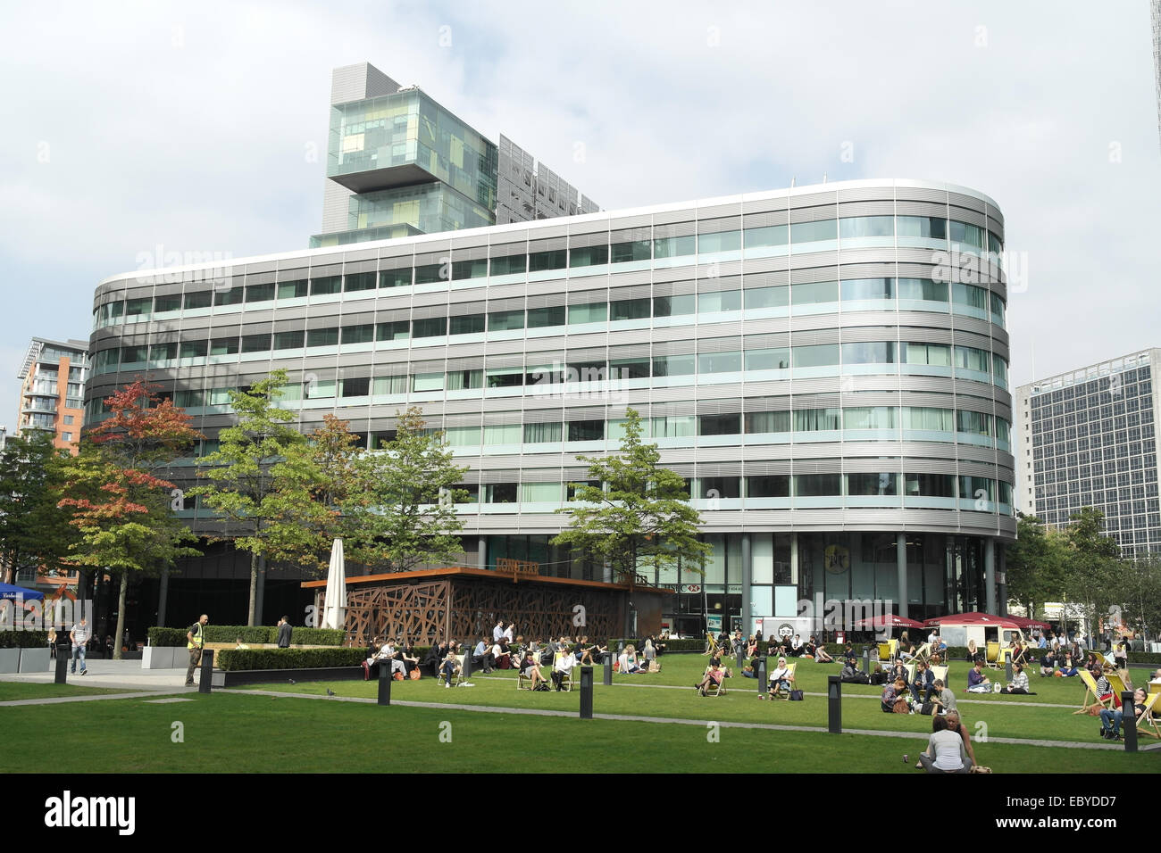 Blue sky white clouds view across green grass Hardman Square, with ...