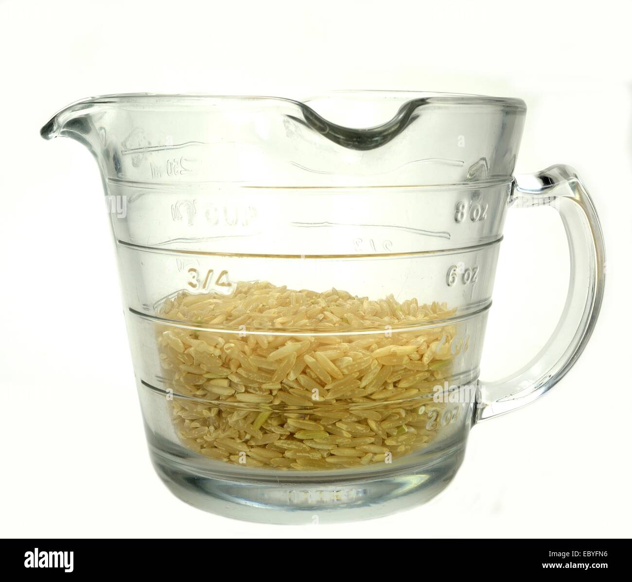 Measuring cup half filled with brown rice on a white background Stock ...