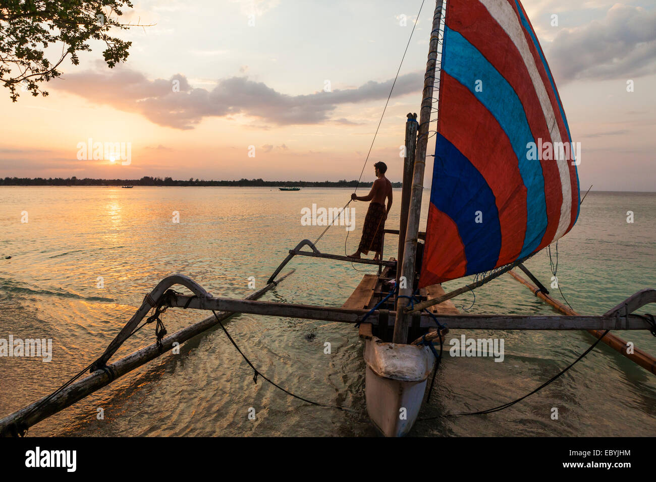 Young man in out rigger boat in Indonesia Stock Photo - Alamy