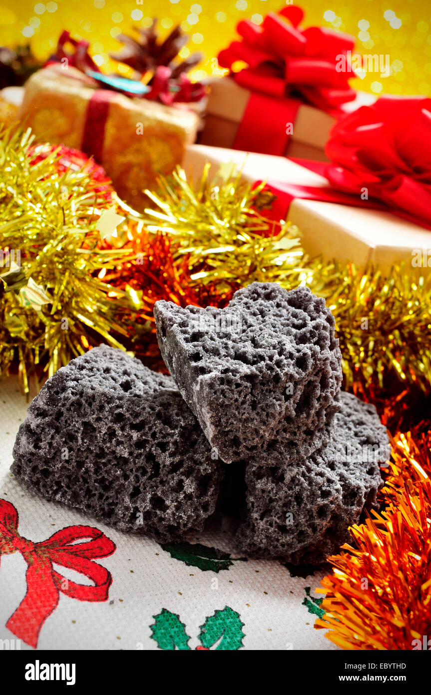 closeup of some lumps of candy coal and some christmas gifts in the ...