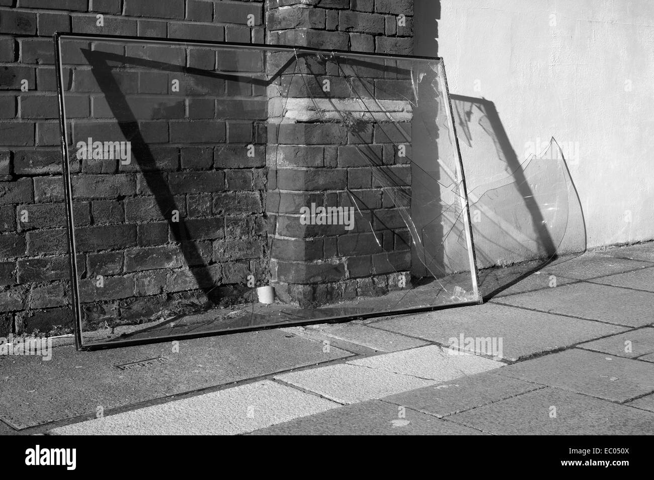 broken glass in window frame dumped on the pavement in an urban road uk ...