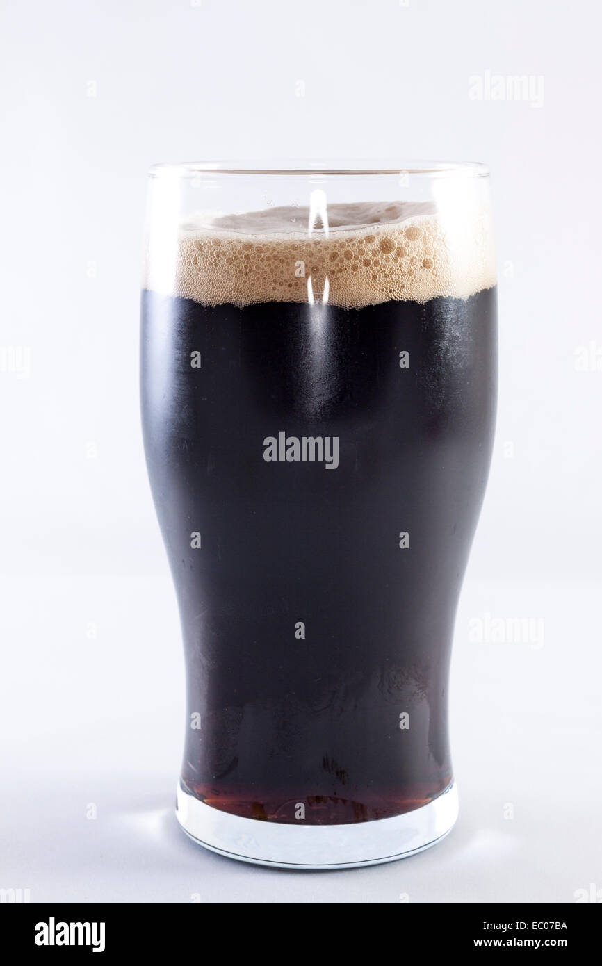 Pint glass of stout against a white background Stock Photo - Alamy