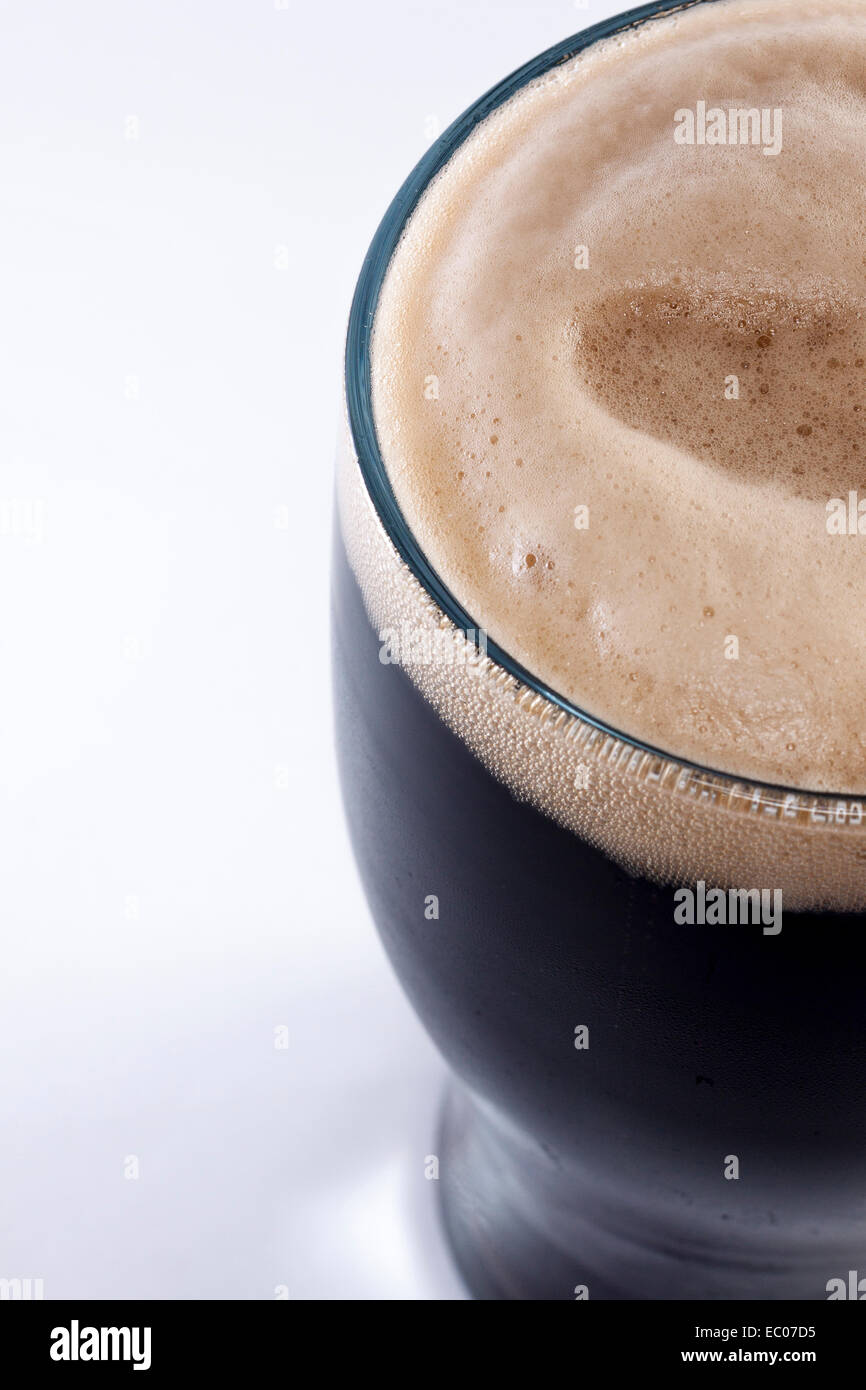 Pint glass of stout against a white background Stock Photo - Alamy
