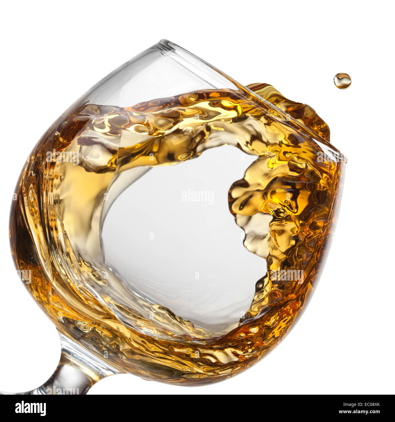 Splash of cognac in glass isolated on white background Stock Photo - Alamy