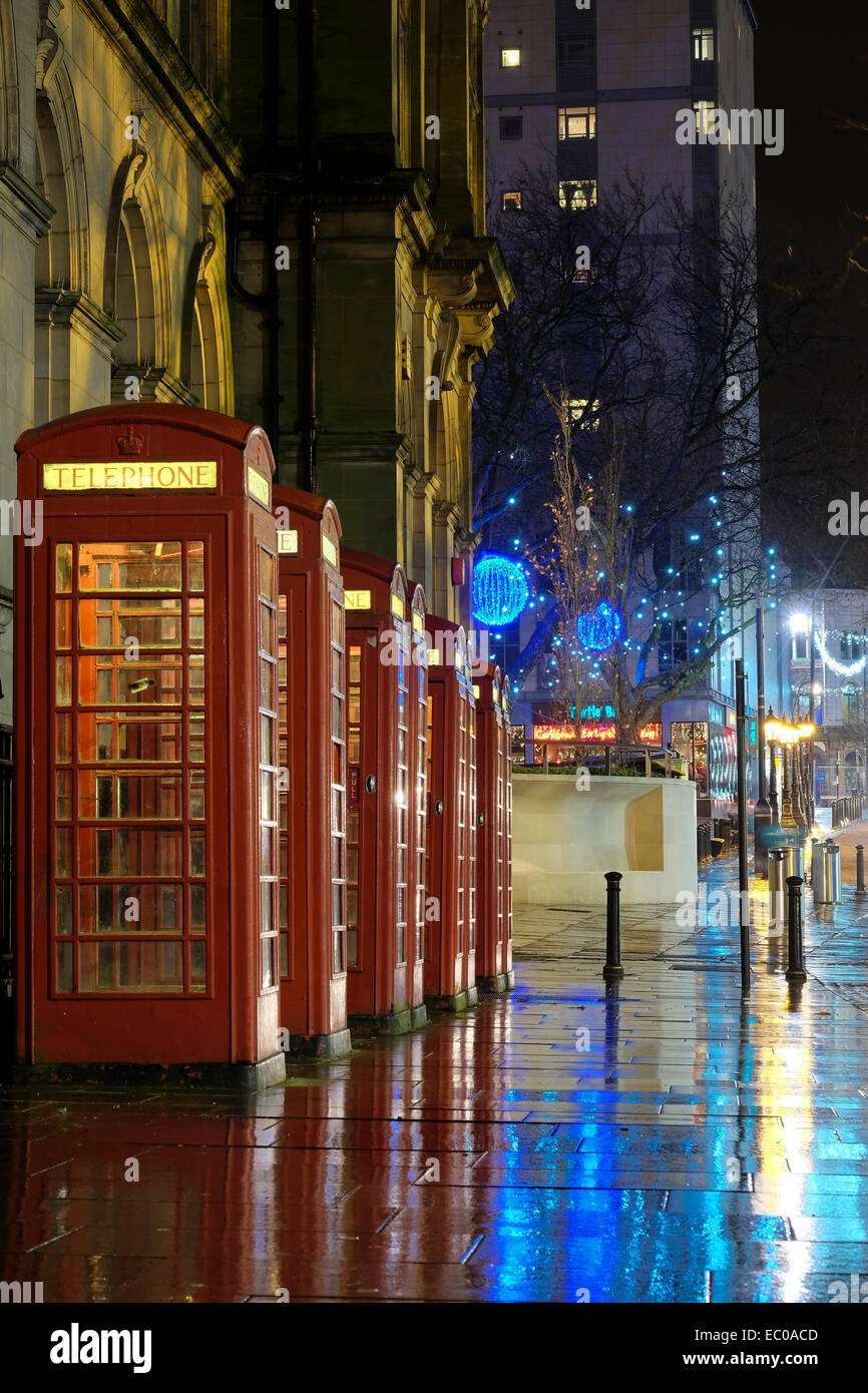 A row of traditional red telephone boxes and festive Christmas lights ...
