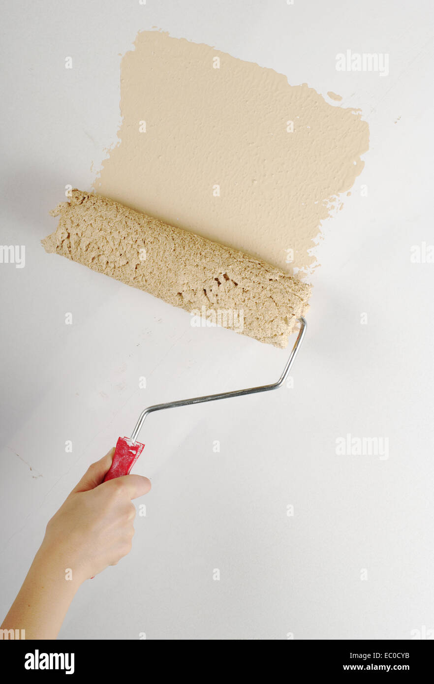 Hand painting with roller on white wall Stock Photo - Alamy