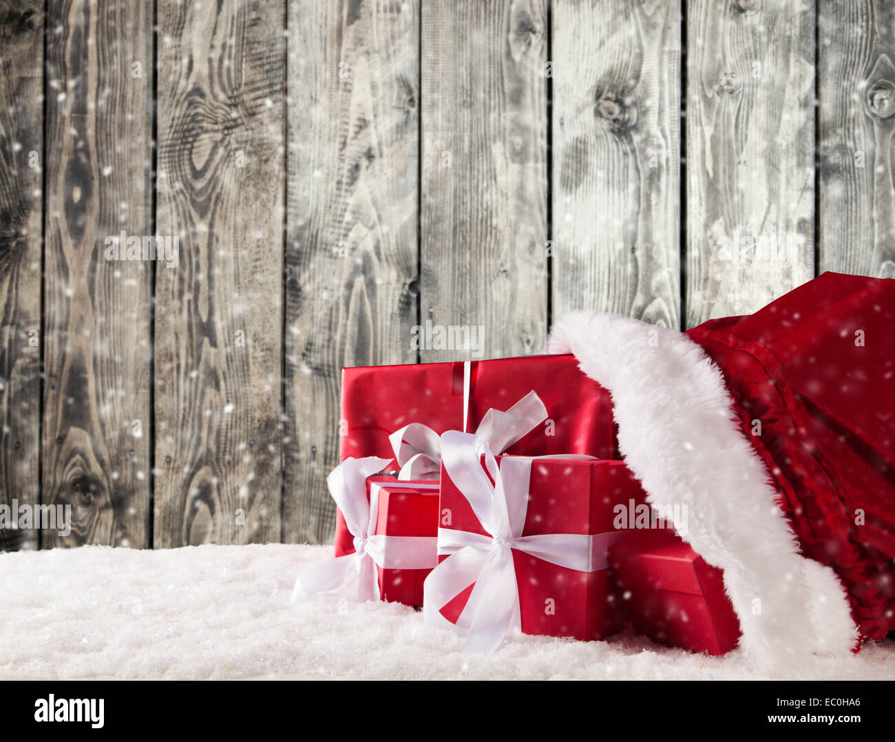 Santa Claus bag full of gifts on snow. Wooden planks as background ...