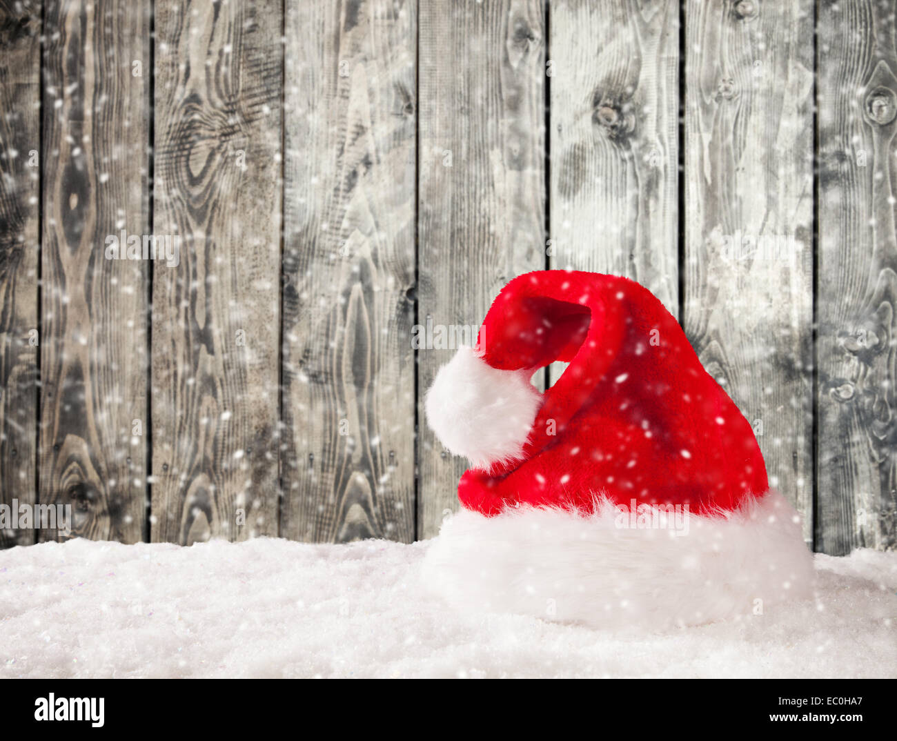 Christmas Santa Claus cap on snow with wooden planks as background ...