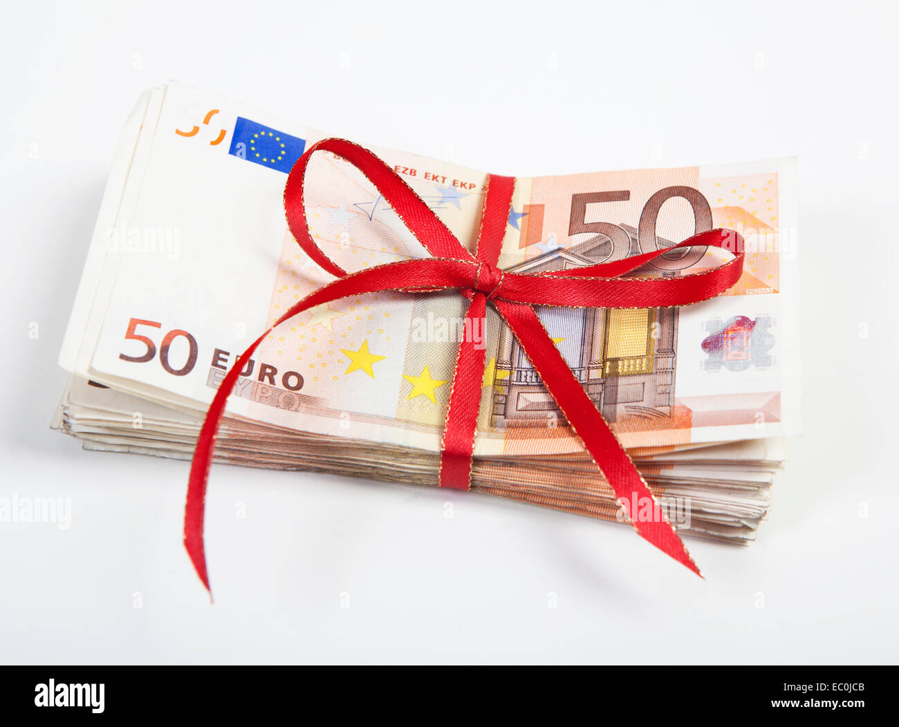 a bundle of euro bills wrapped with a red ribbon. white background ...