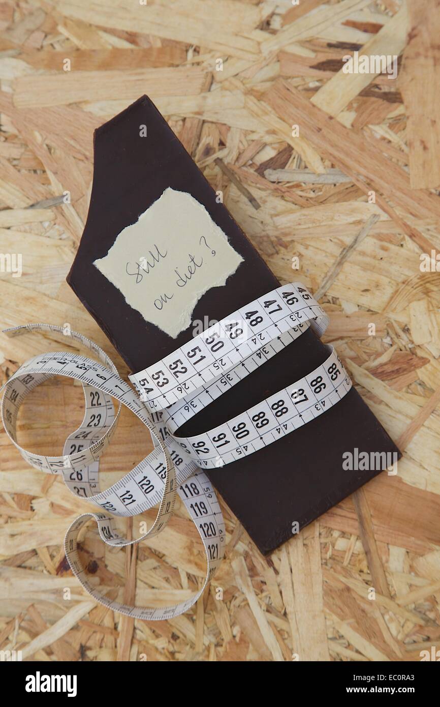 A measuring band around bar of chocolate. A message written on the ...