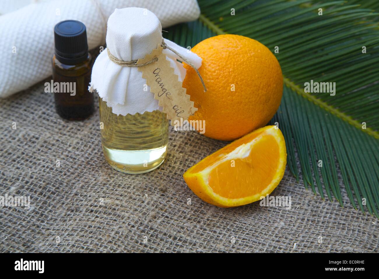 Bottle of orange oil. Fresh oranges in the background Stock Photo - Alamy