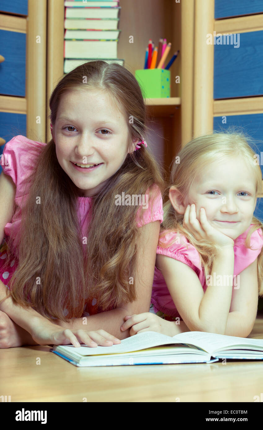 two girls reads book in your room Stock Photo - Alamy