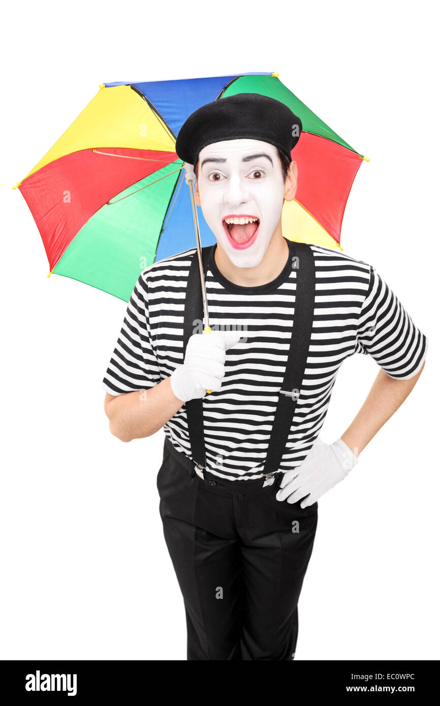 Excited mime artist holding a colorful umbrella isolated on white ...