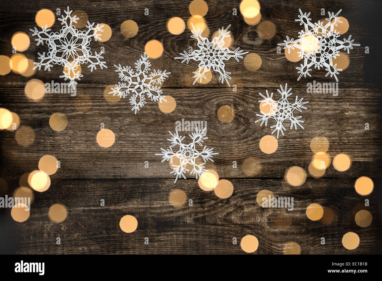 christmas decoration snowflakes and defocused lights over rustic wooden ...