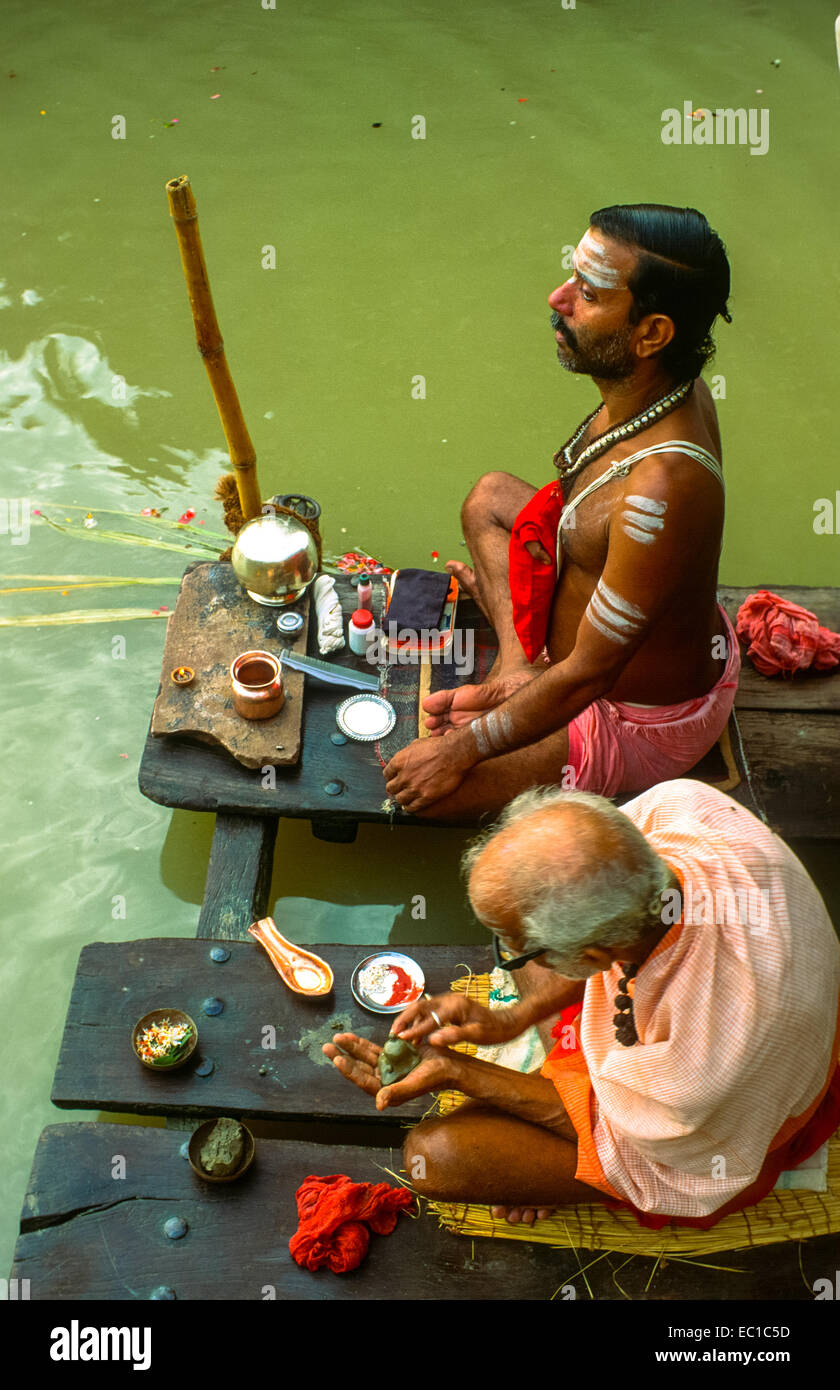 two men praying at the ganga river in varanasi in india Stock Photo - Alamy