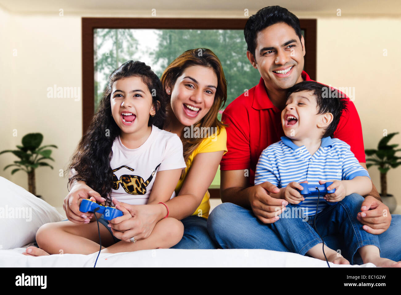 indian Parents with children playing Video Game Stock Photo - Alamy