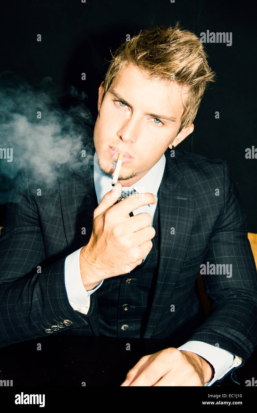 Young man in three piece suit smoking Stock Photo - Alamy