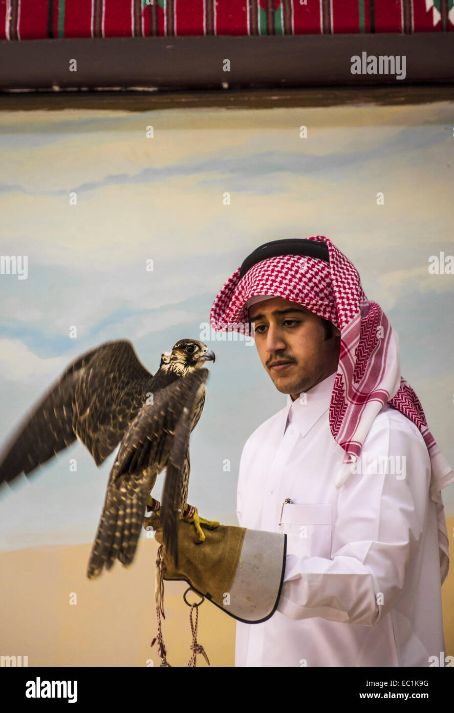 Arab examining falcon in Doha city shop. The falcon is the national ...