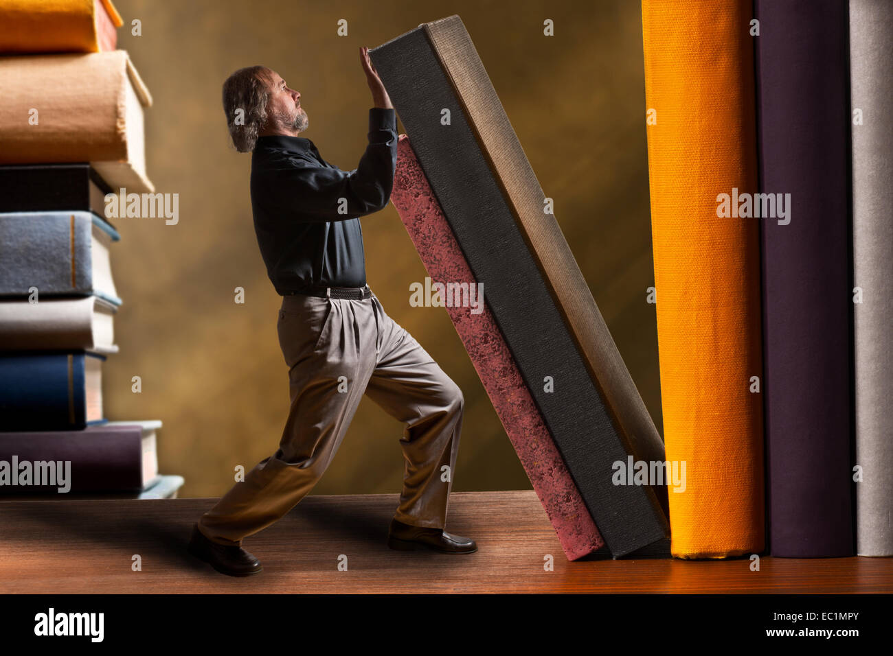 reader supporting falling book in the bookshelf Stock Photo - Alamy