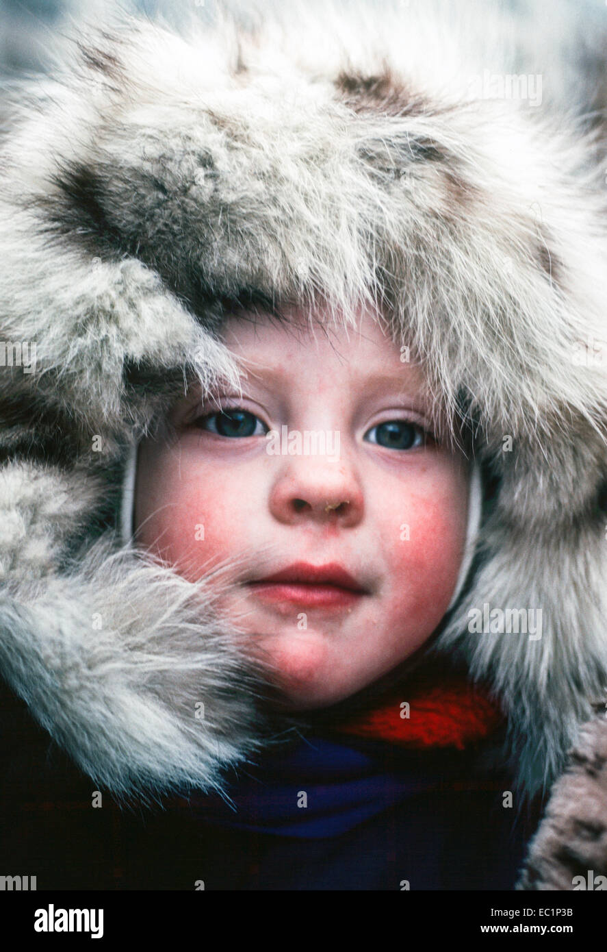 Young child dressed in winter clothes and fur hat for recess in the ...