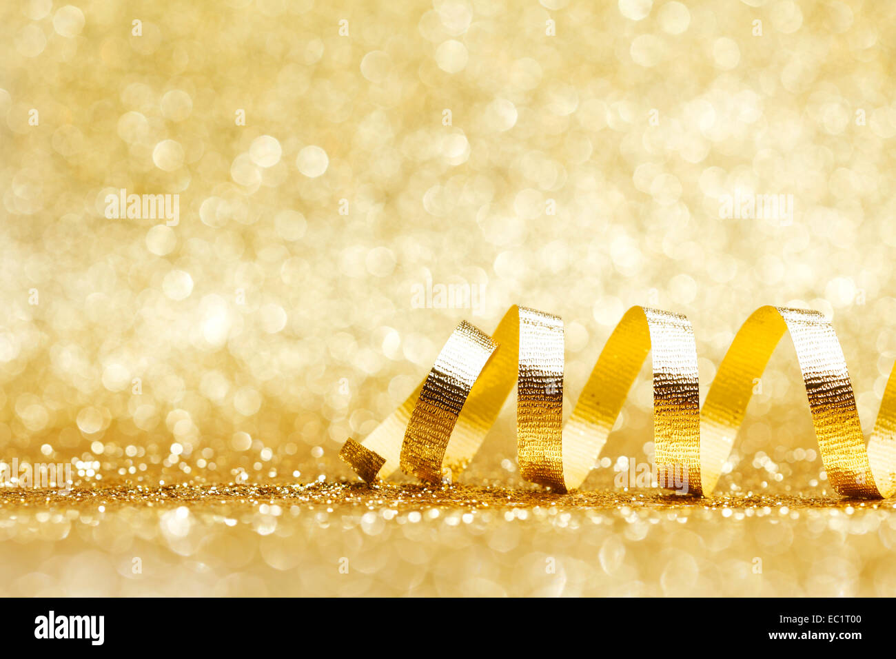 Golden curly ribbon decoration on glitter background close-up Stock ...