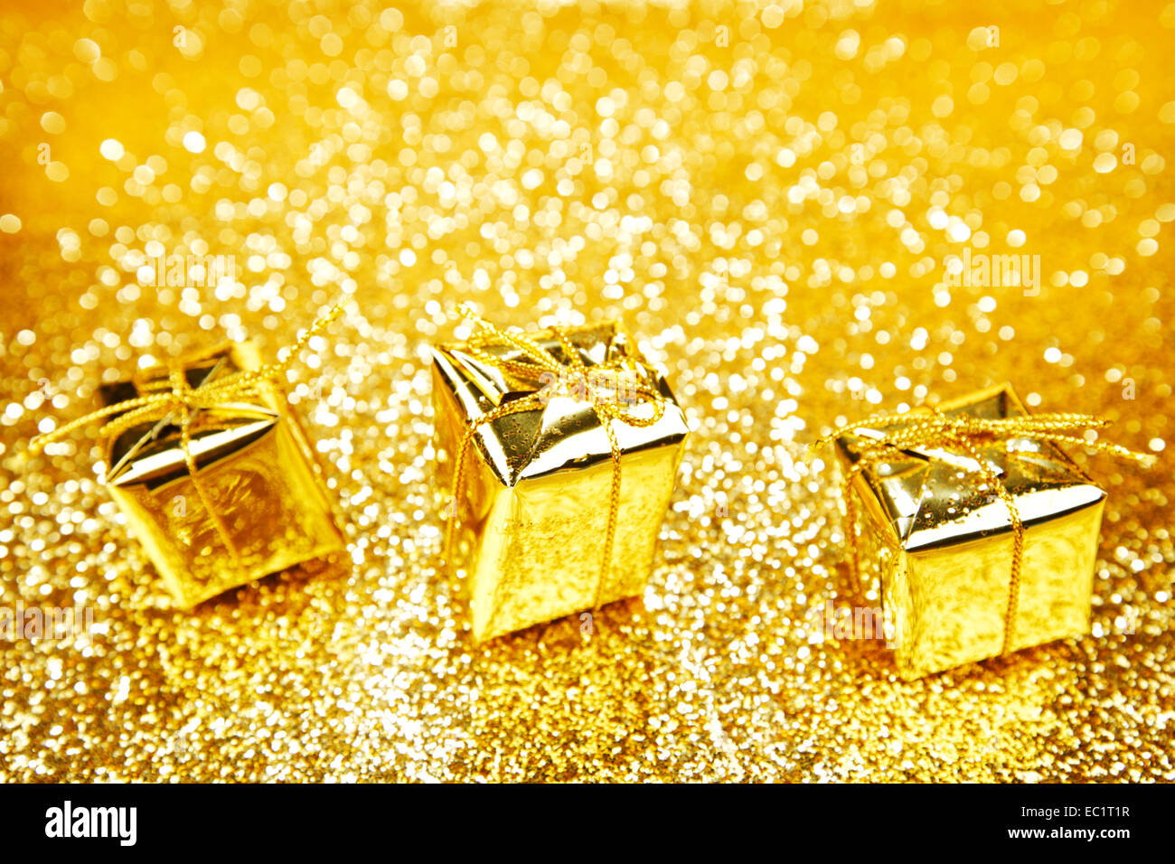 Gold decorative boxes with holiday gifts on abstract gold background ...