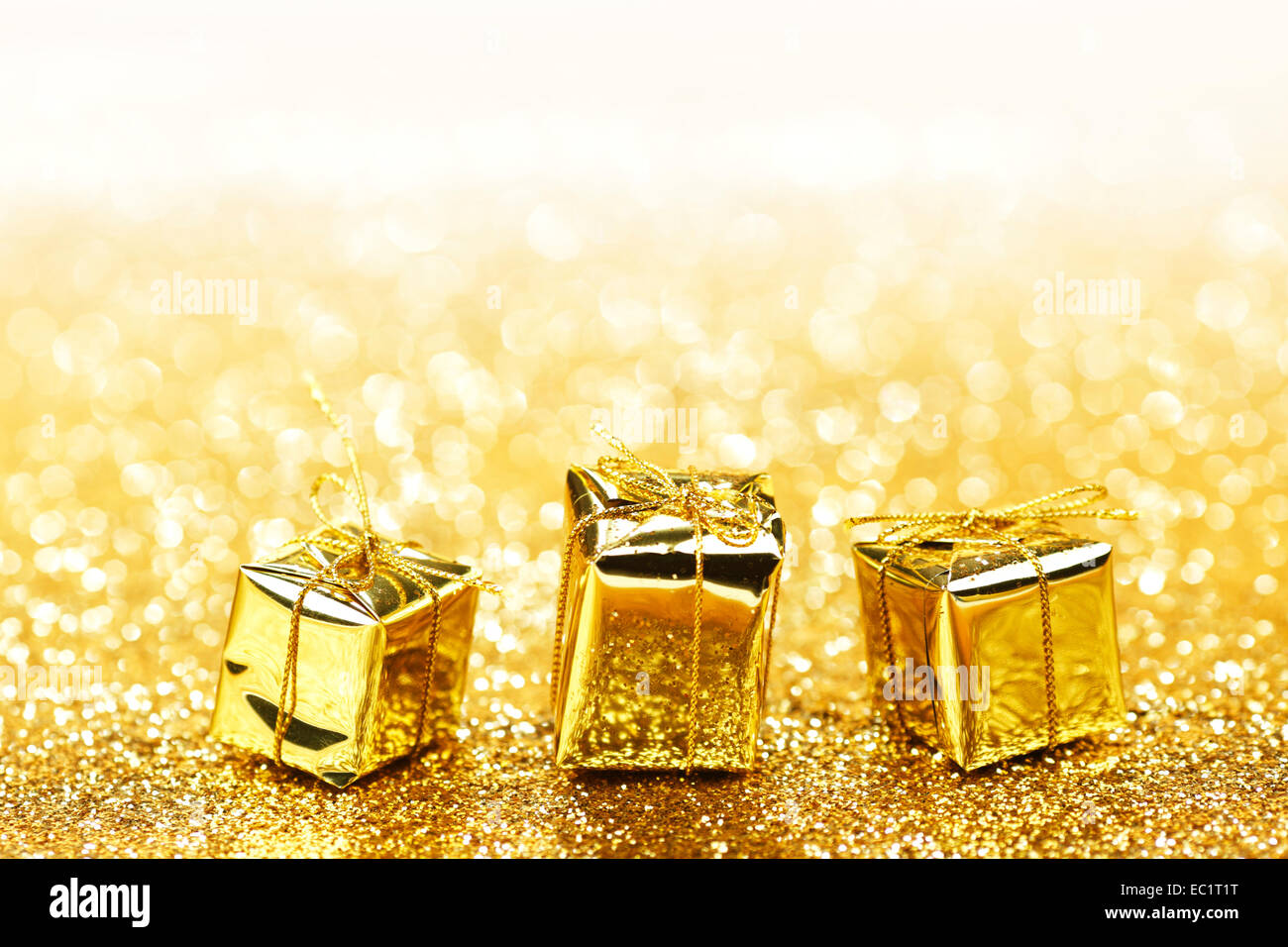 Gold decorative boxes with holiday gifts on abstract gold background ...