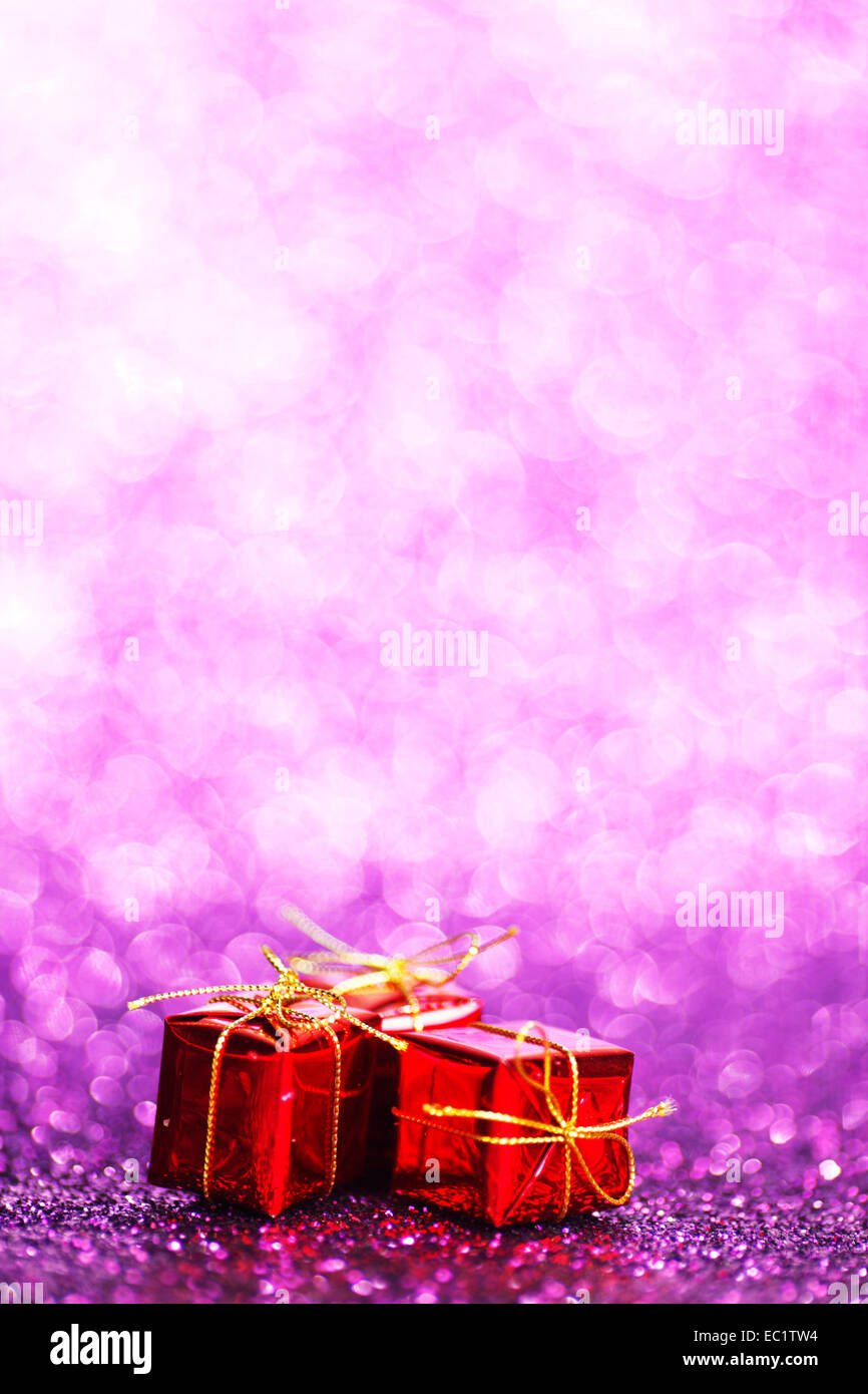 Red Christmas gift boxes on shiny glitter purple background Stock Photo ...