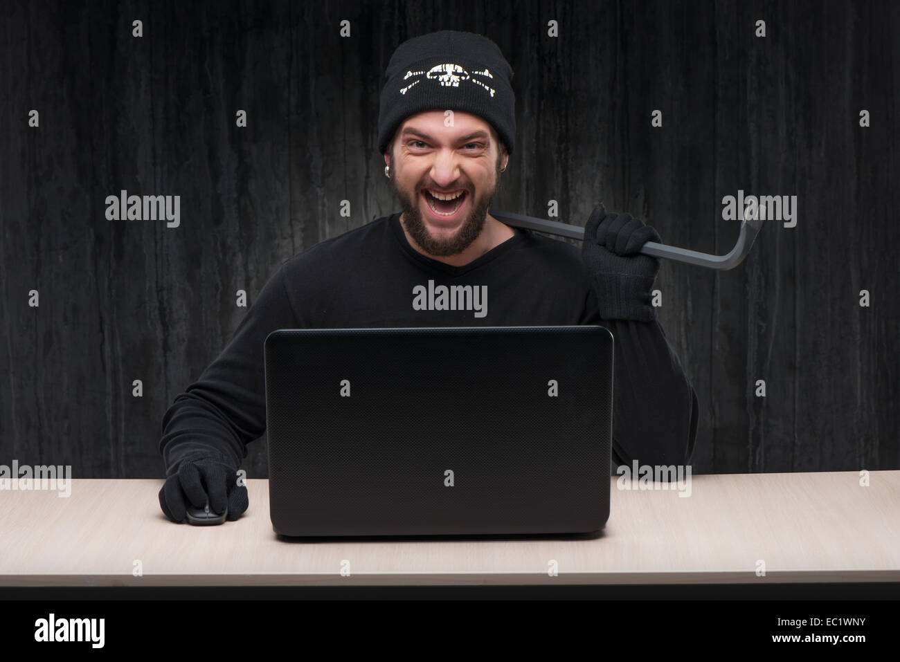 Computer hacker at work with a laptop holding breaker. Computer hacker ...