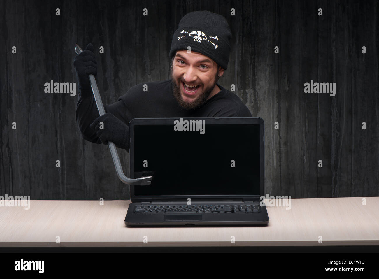 Computer hacker at work with a laptop holding breaker. Computer hacker ...