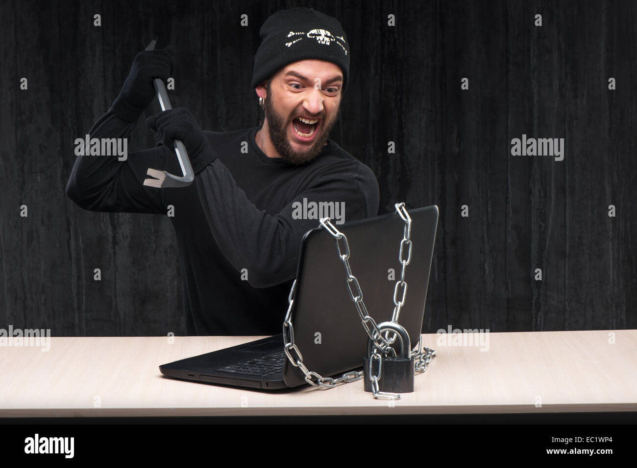 Nervous computer hacker with breaker trying to unlock laptop. Computer ...